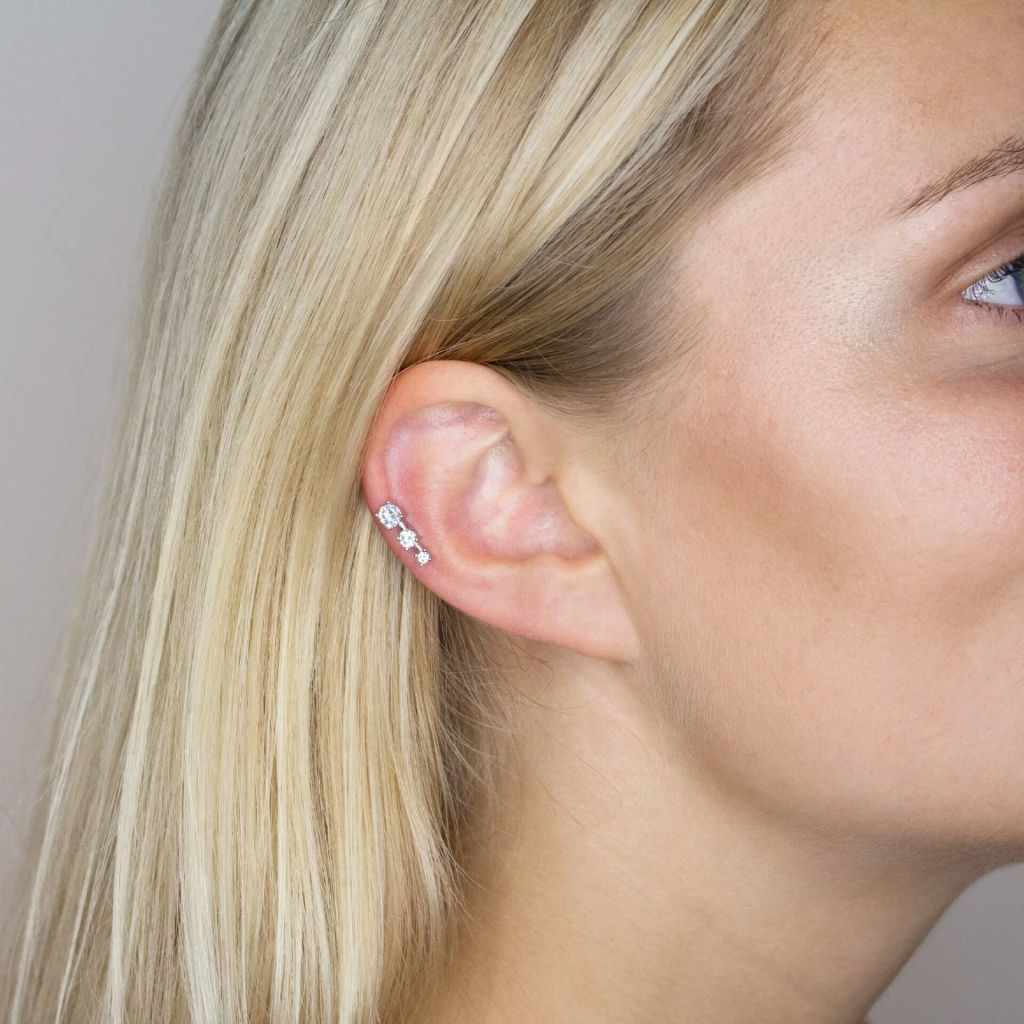 Leuke oorpiercing met drie steentjes